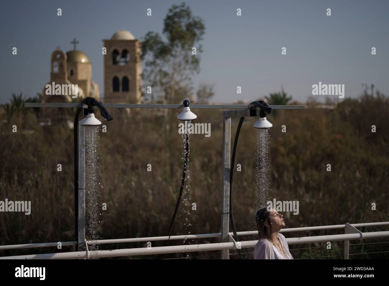 Greek Orthodox pilgrim bathes in water from the Jordan River that ...