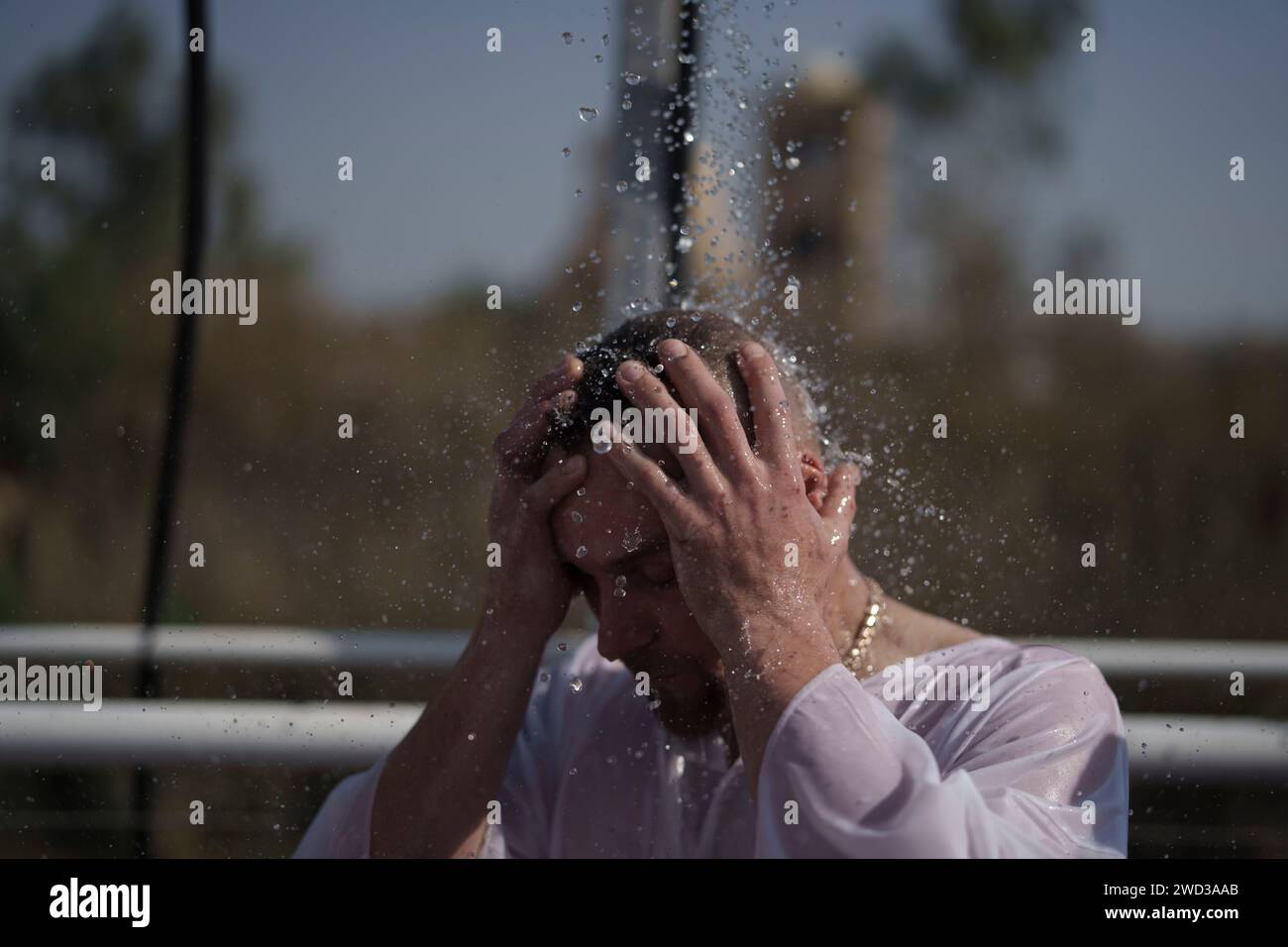 Greek Orthodox pilgrim bathes in water from the Jordan River that ...