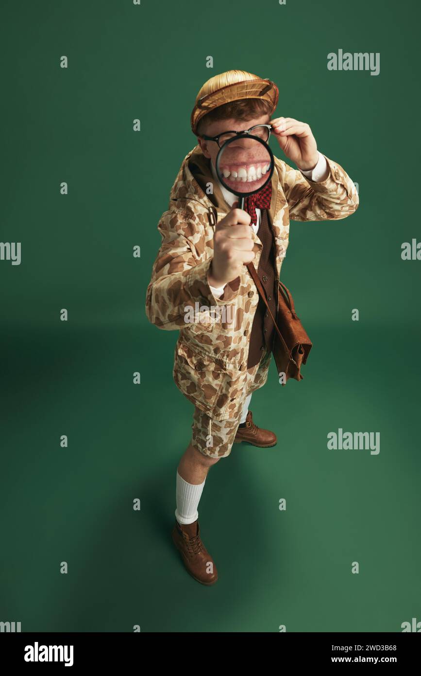 Funny image of young man in image of detective looking in magnifying ...