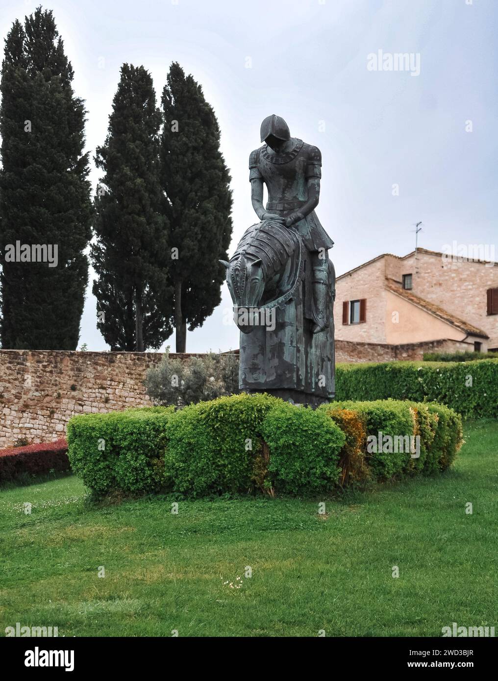 A statue amidst lush green field, surrounded by towering trees Stock ...