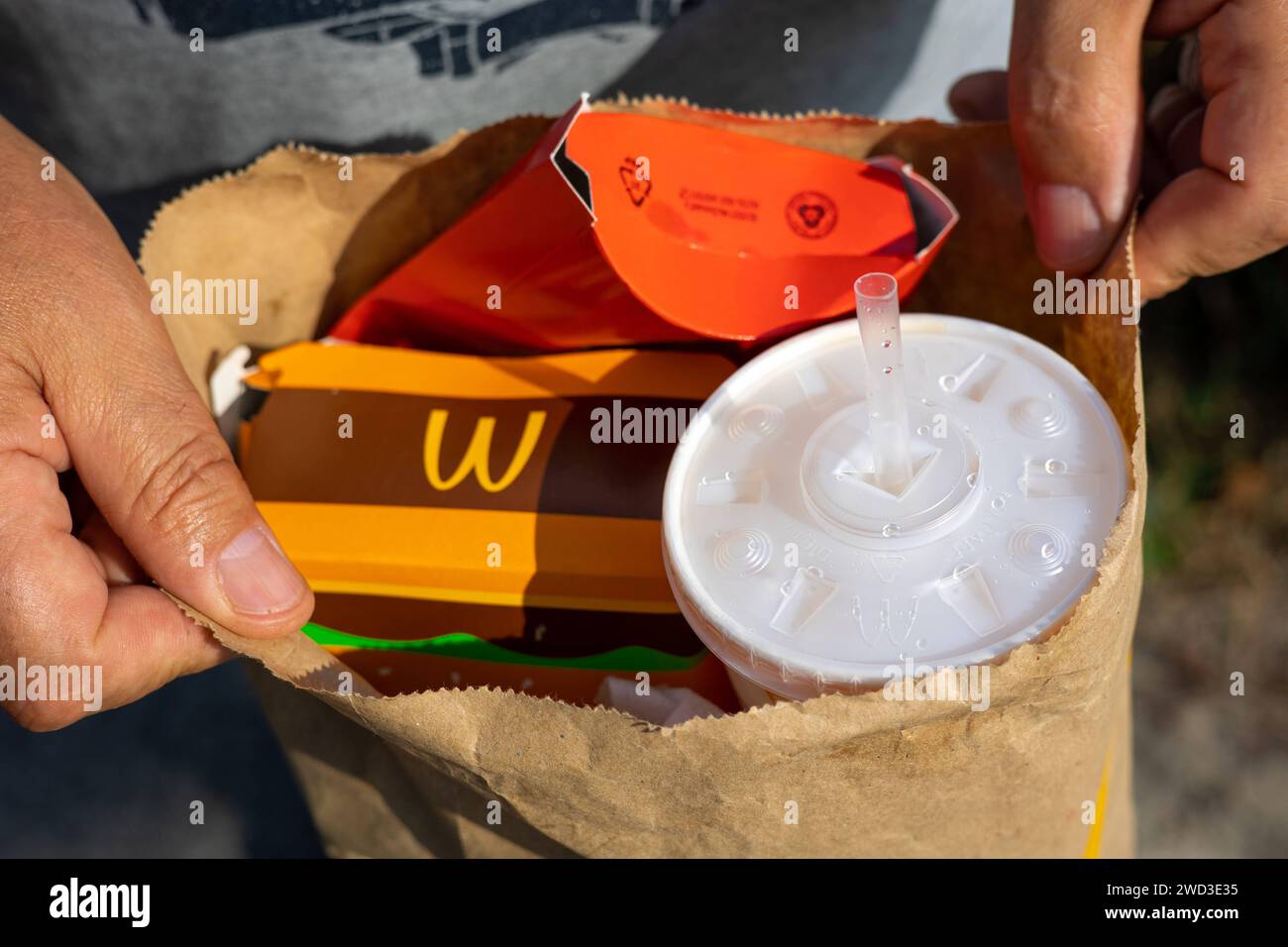 Used paper disposable packs McDonalds in male hands. Fast foods litter ...