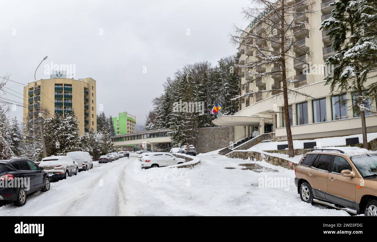 Snow-covered city street with apartments and condominium buildings ...