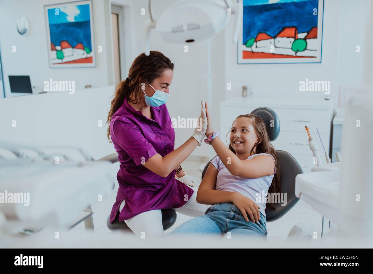 A caring dentist engages in a joyful conversation and entertains a ...