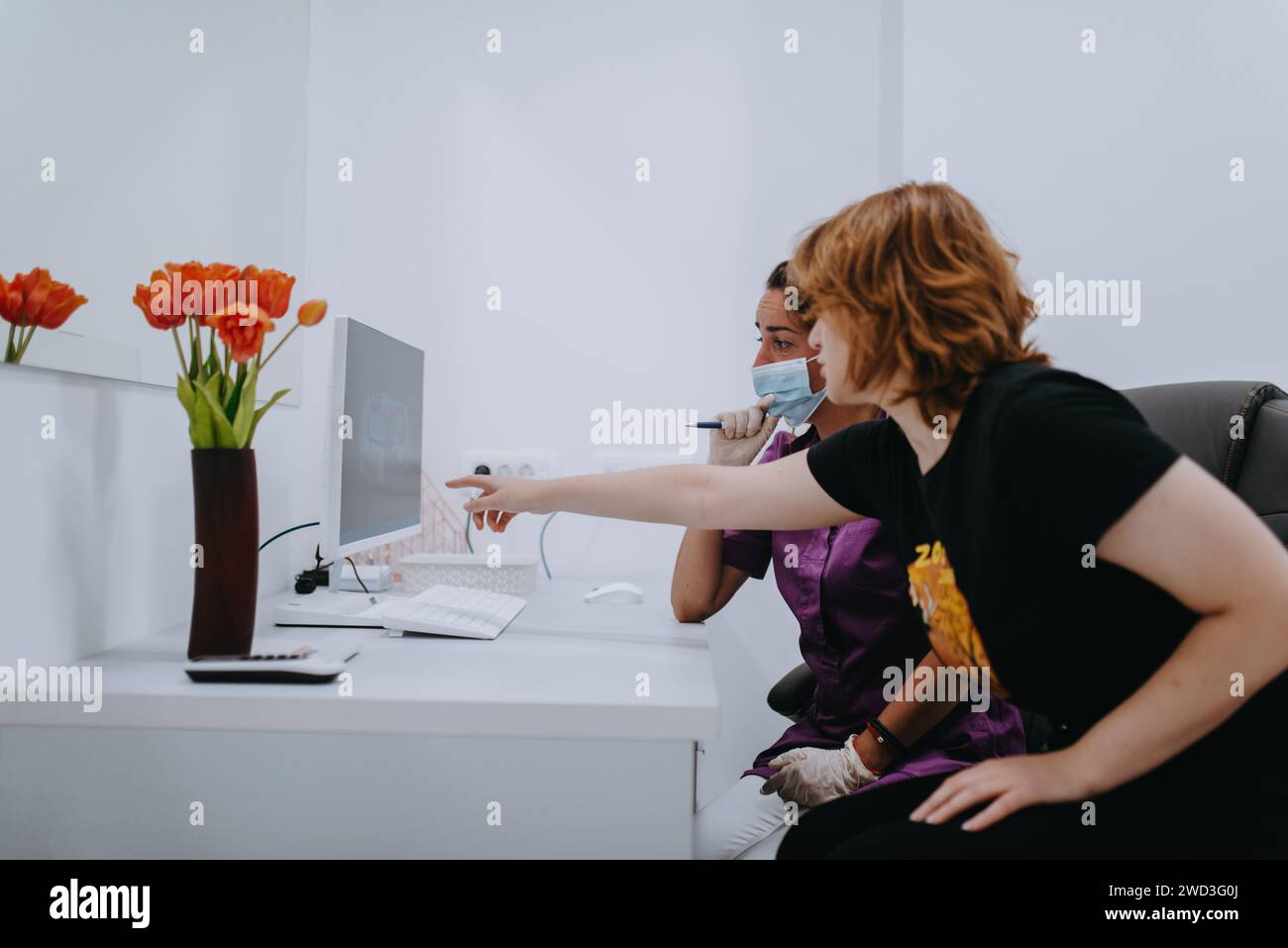 In a modern dental office, a dentist and a young patient engage in a ...