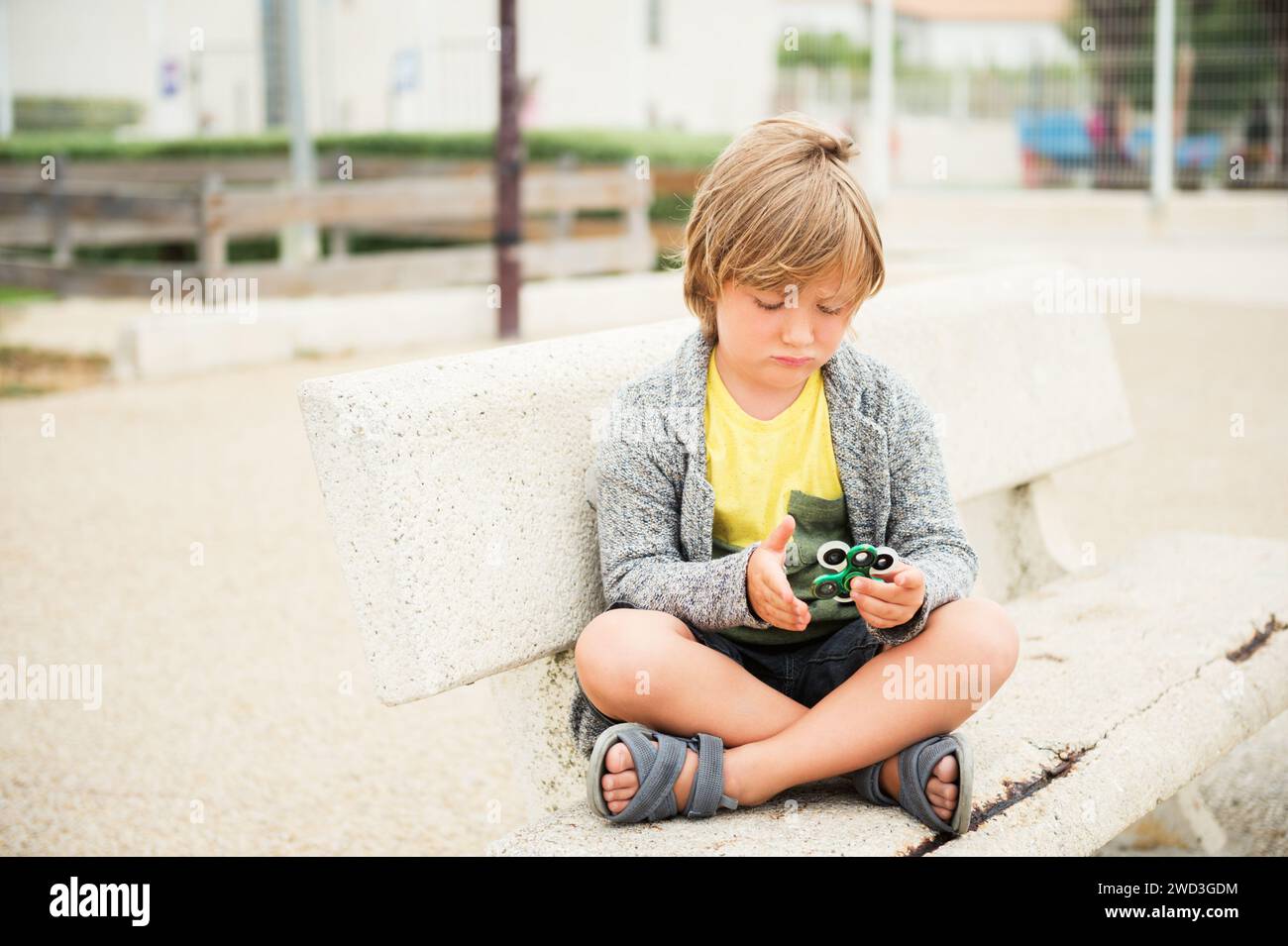 Very sad kid playing with fidget hand spinners Stock Photo - Alamy