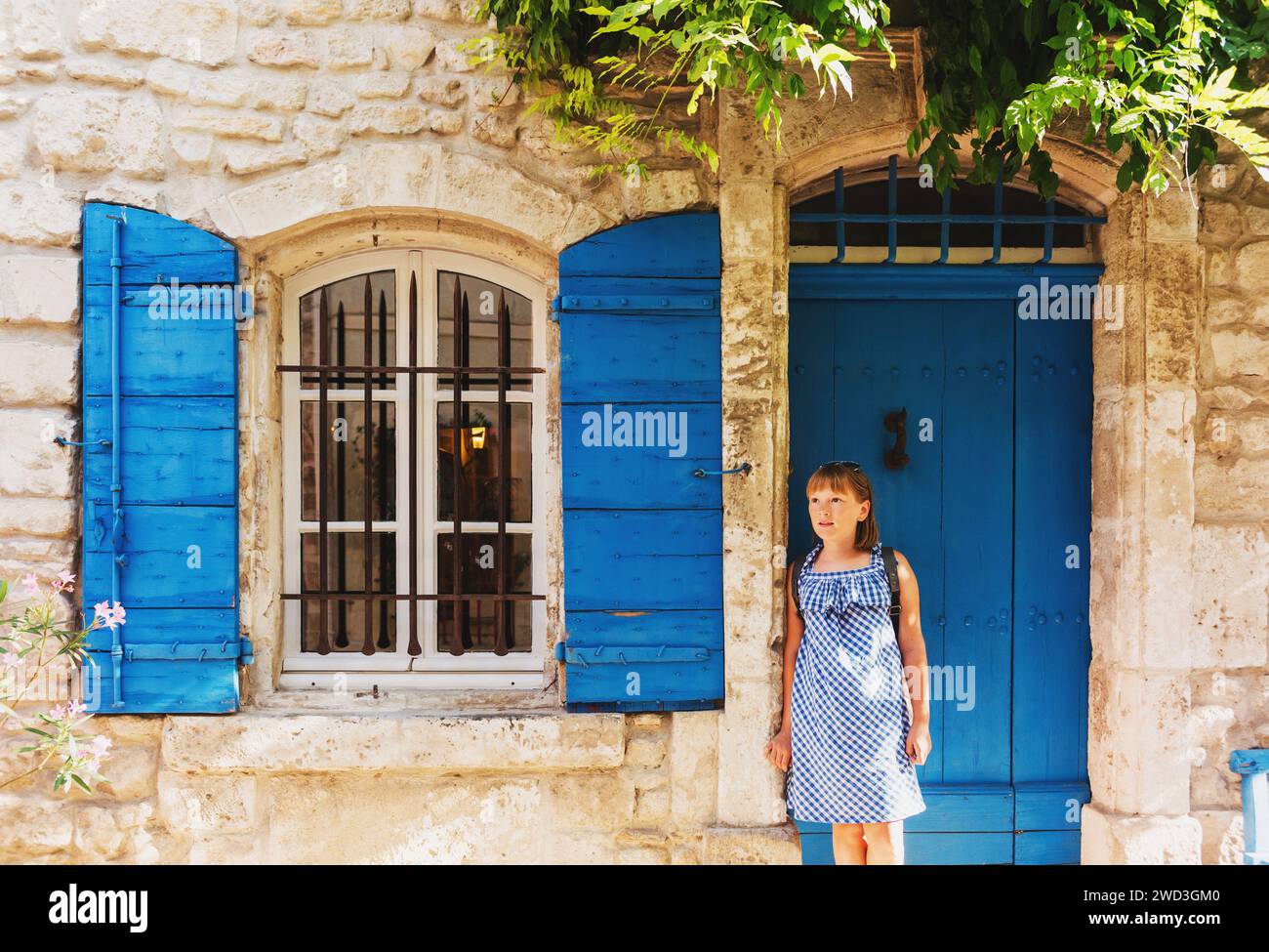 Pretty little girl tourist on the streets of Provence, Wearing blue ...