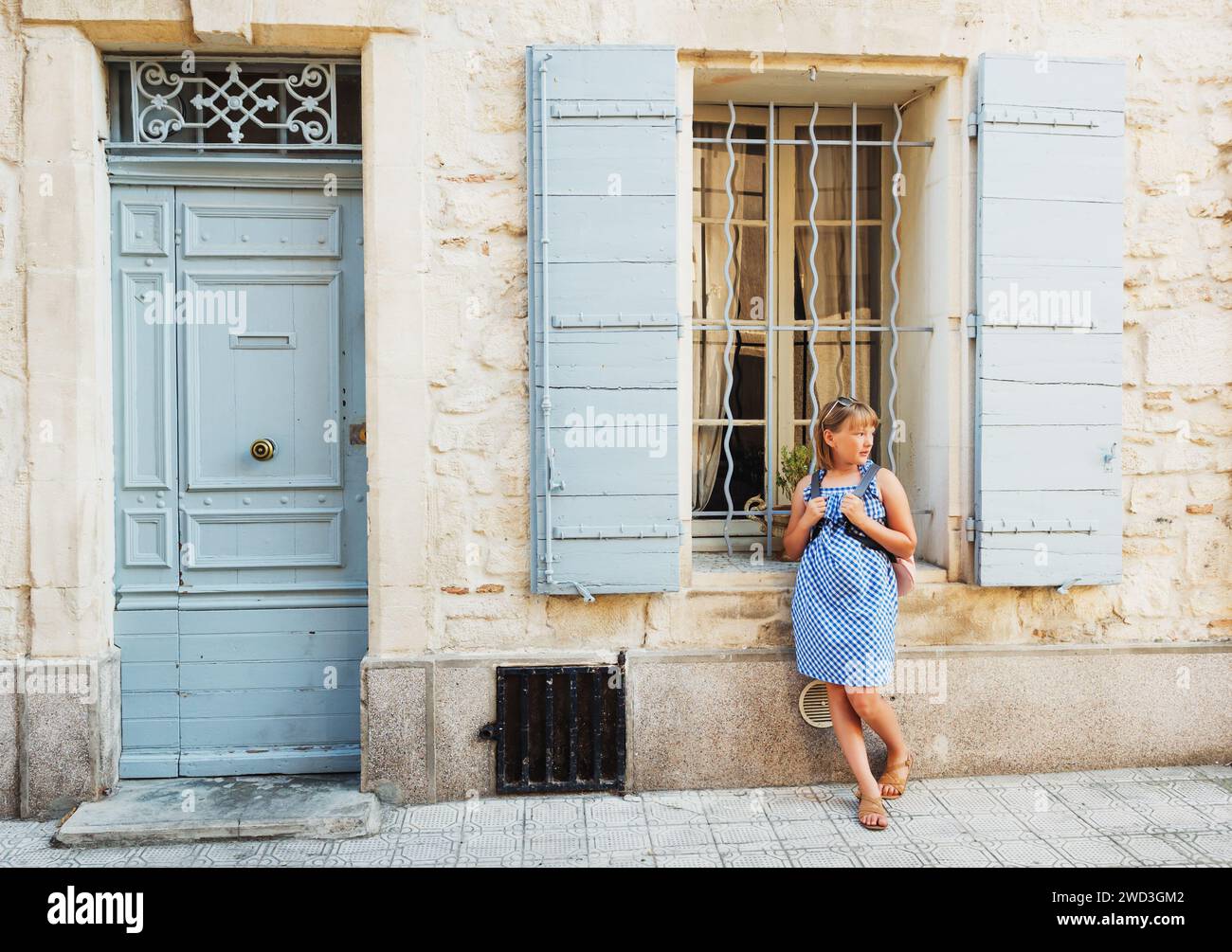 Pretty little girl tourist on the streets of Provence, Wearing blue ...