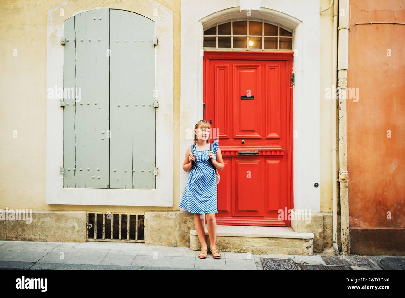 Pretty little girl tourist on the streets of Provence, Wearing blue ...