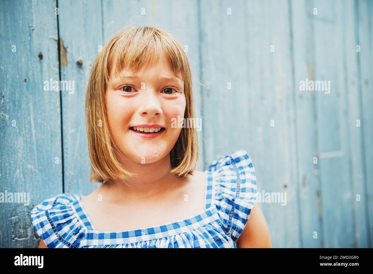 Close up portrait of adorable kid girl wearing blue gingham dress ...