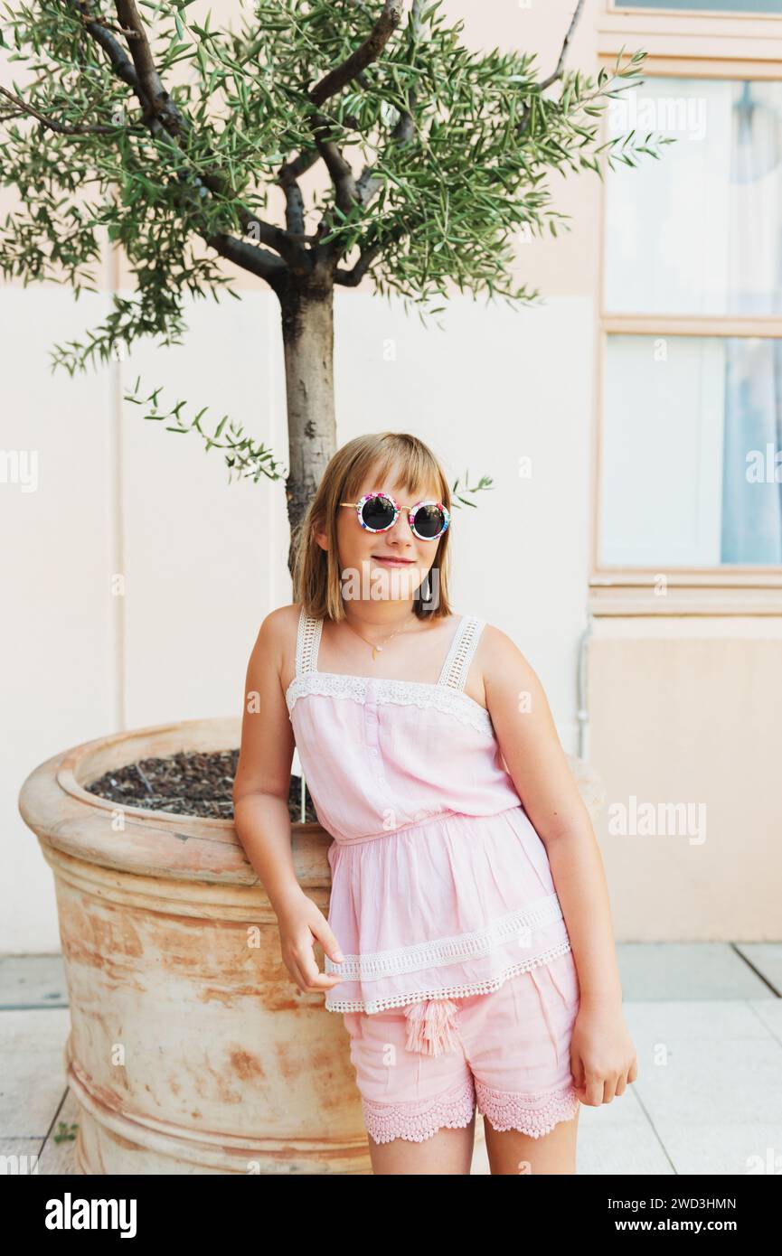 Outdoor portrait of adorable preteen kid girl wearing fashion pink top ...