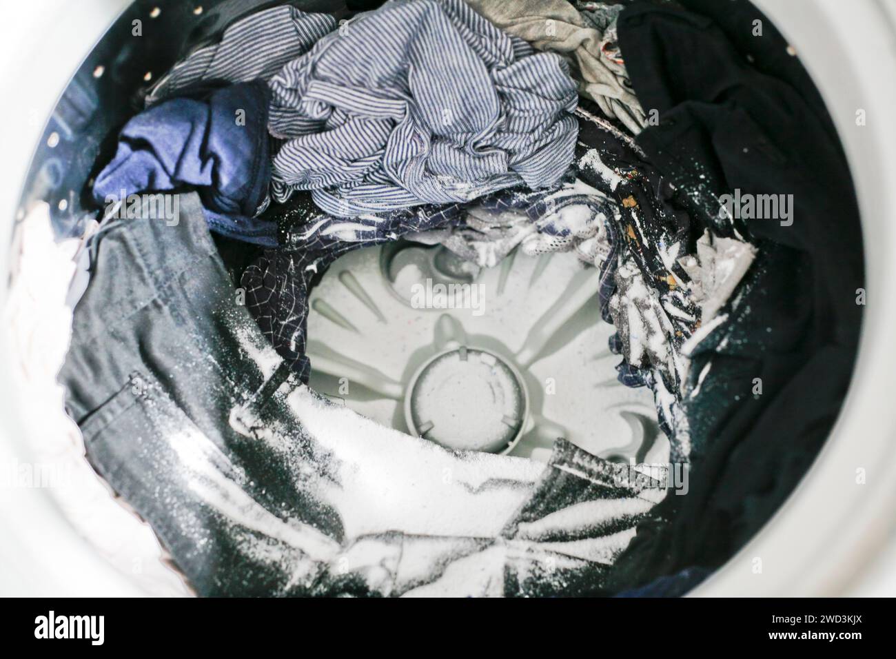 Dirty clothes with detergent powder inside washing machine Stock Photo ...