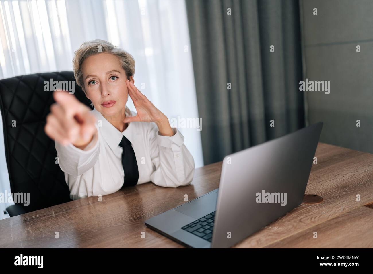 Portrait of displeased middle-aged business woman boss sitting in ...