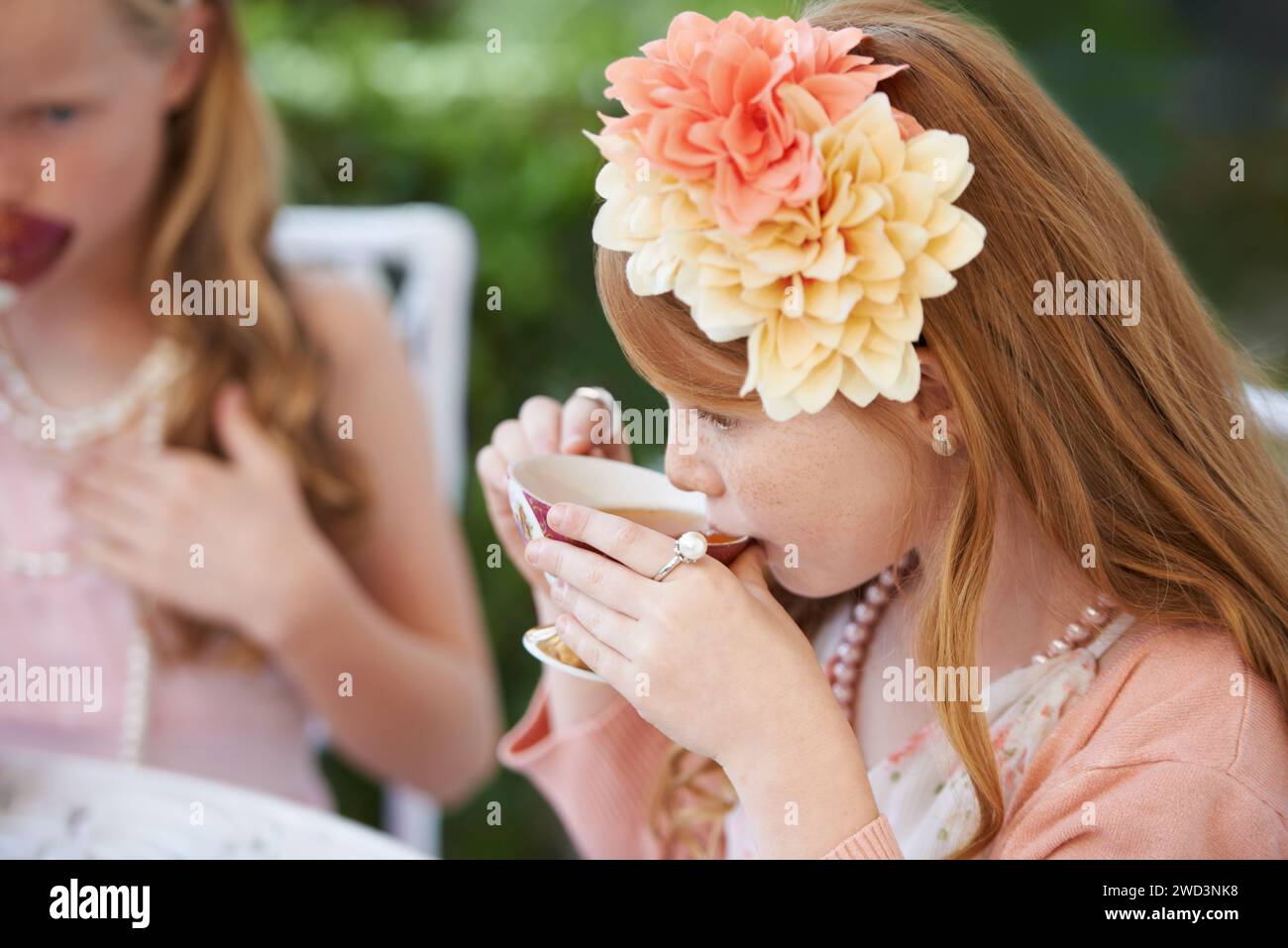 Girl, child and drinking tea in garden with party for birthday ...