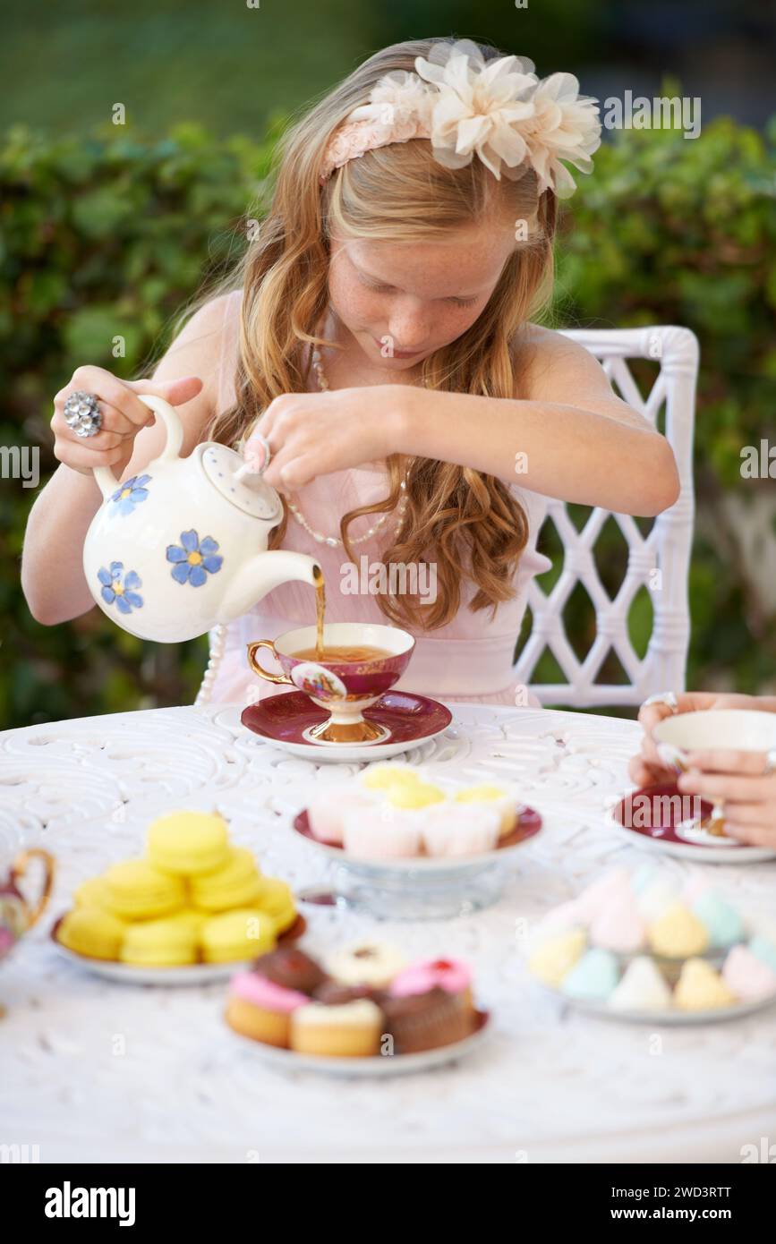 Girl, child and pouring tea in garden with party for birthday ...