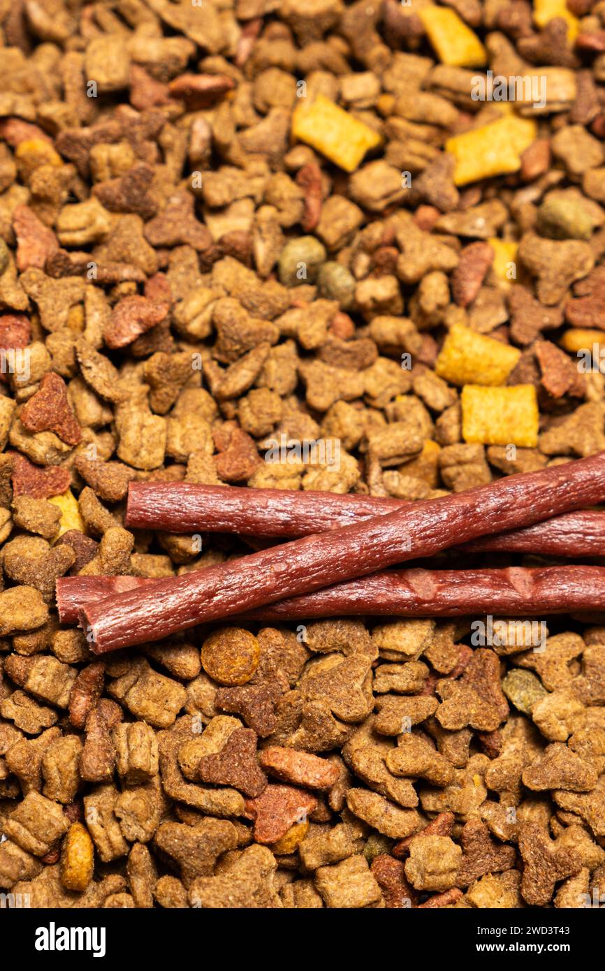 Treats for cats meat sticks sausages against the background of dry food ...