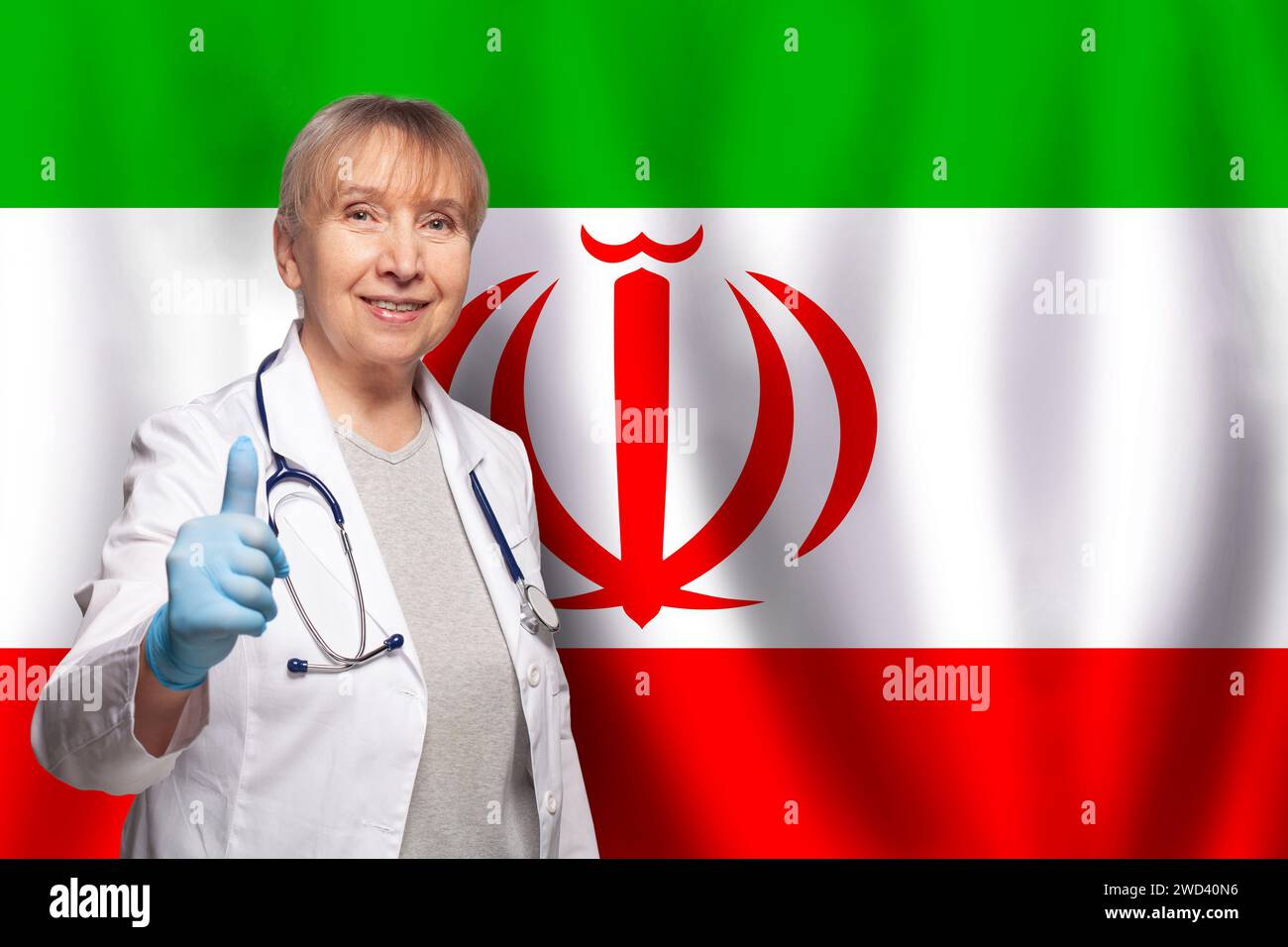 Irani smiling mature doctor woman holding stethoscope on flag of Irani ...