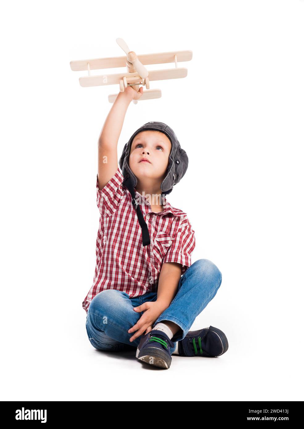 little boy with pilot hat and toy airplane sitting isolated on white ...