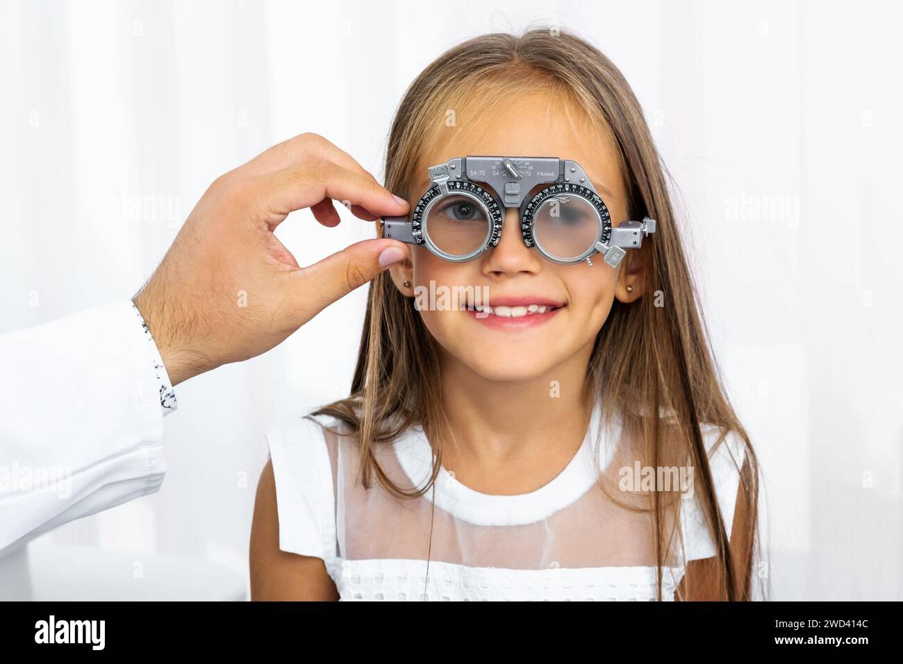 Doctor holding special eye equipment examinating girl's eyes Stock ...