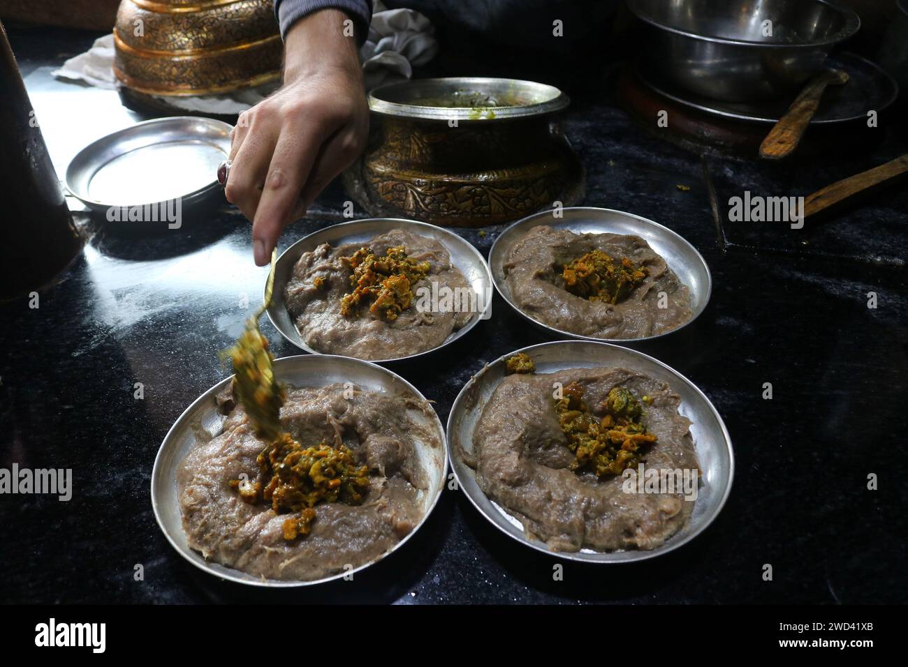 Srinagar Kashmir, India. 18th Jan, 2024. A chef garnishes Harissa for ...