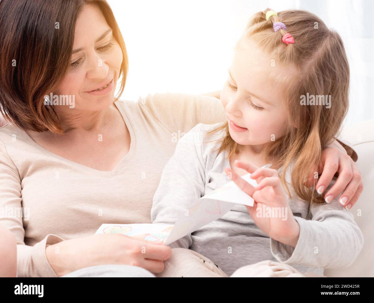 Happy smiling mom looking at the mother's day greeting card made by ...