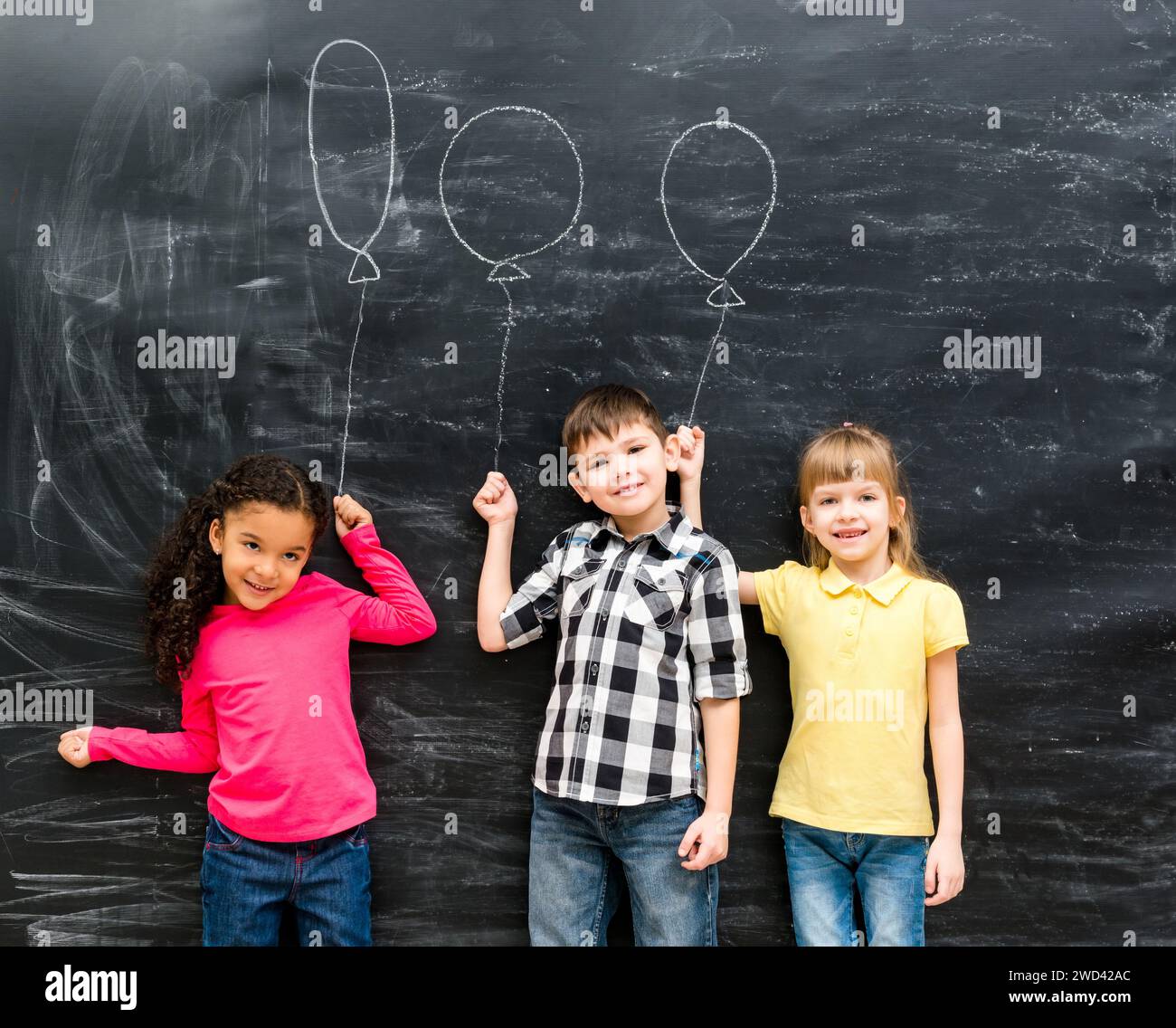 three joyful laughing children keep imaginary balloons drawn on the ...