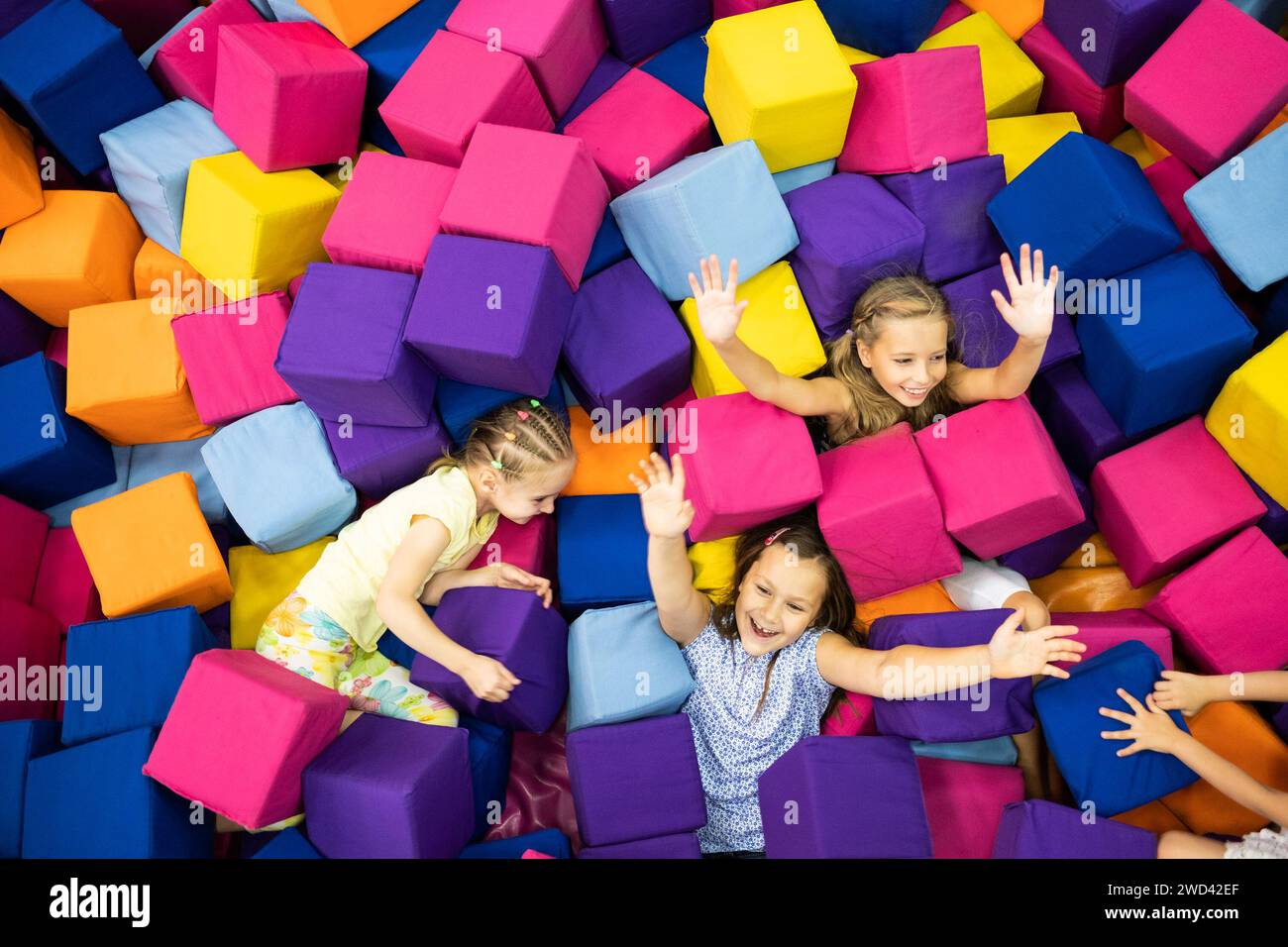 Little smiling girls and joyfully playing with colorful soft cubes in ...
