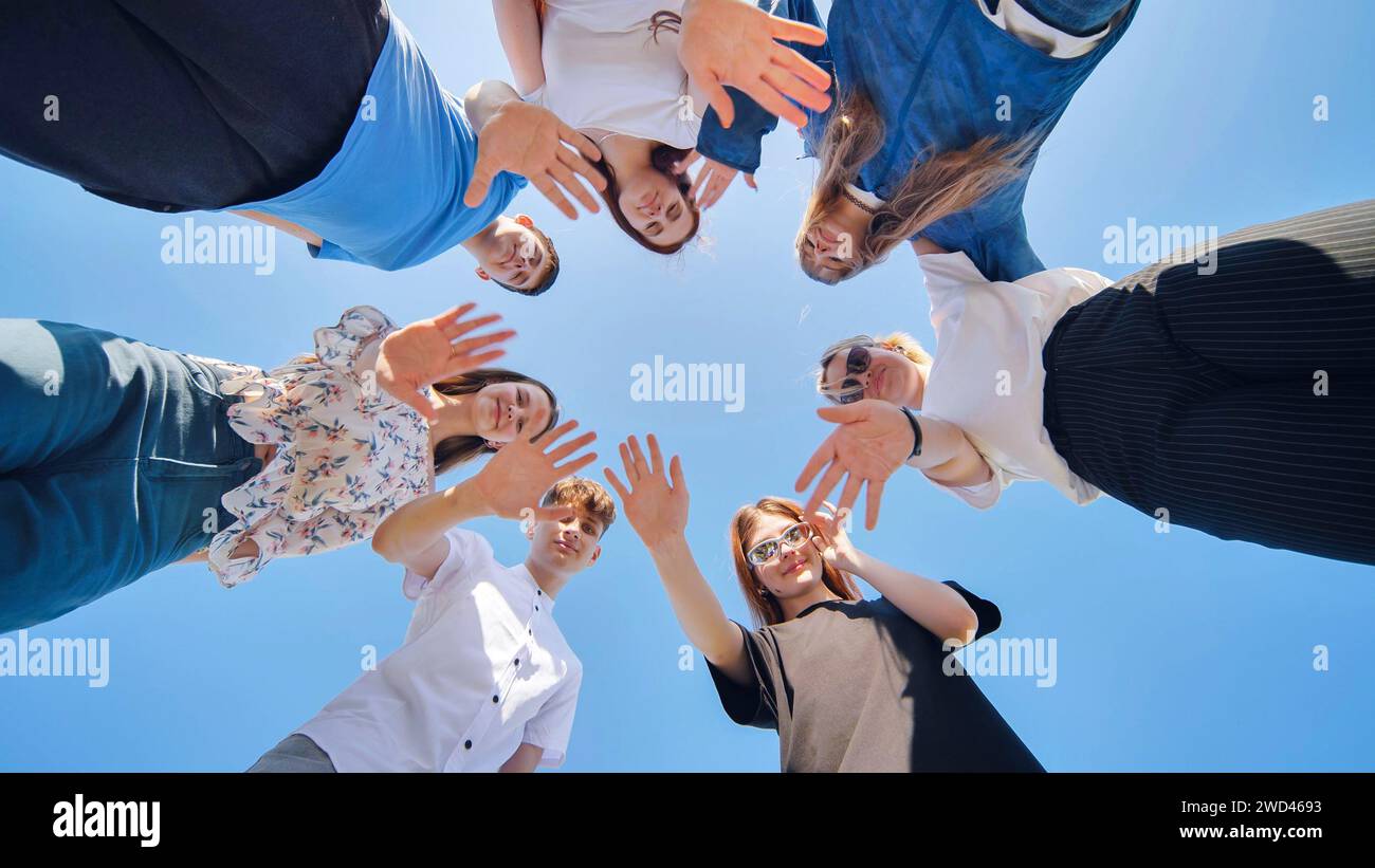 The young friends stand in a circle and wave their hands Stock Photo ...