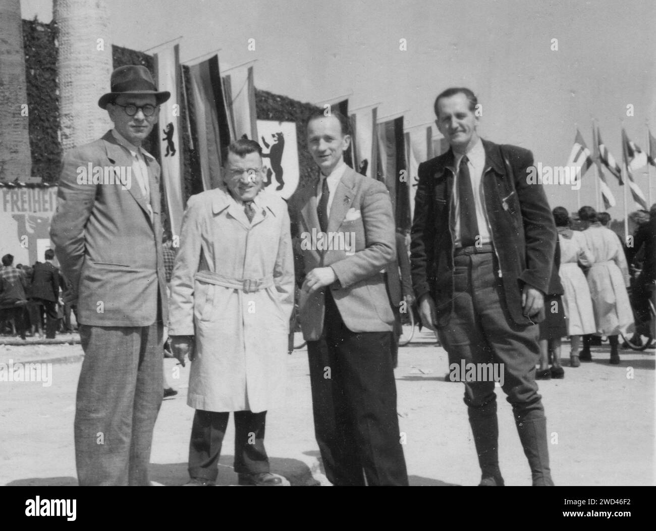 An antique photo shows a group of four men posing during a celebration ...