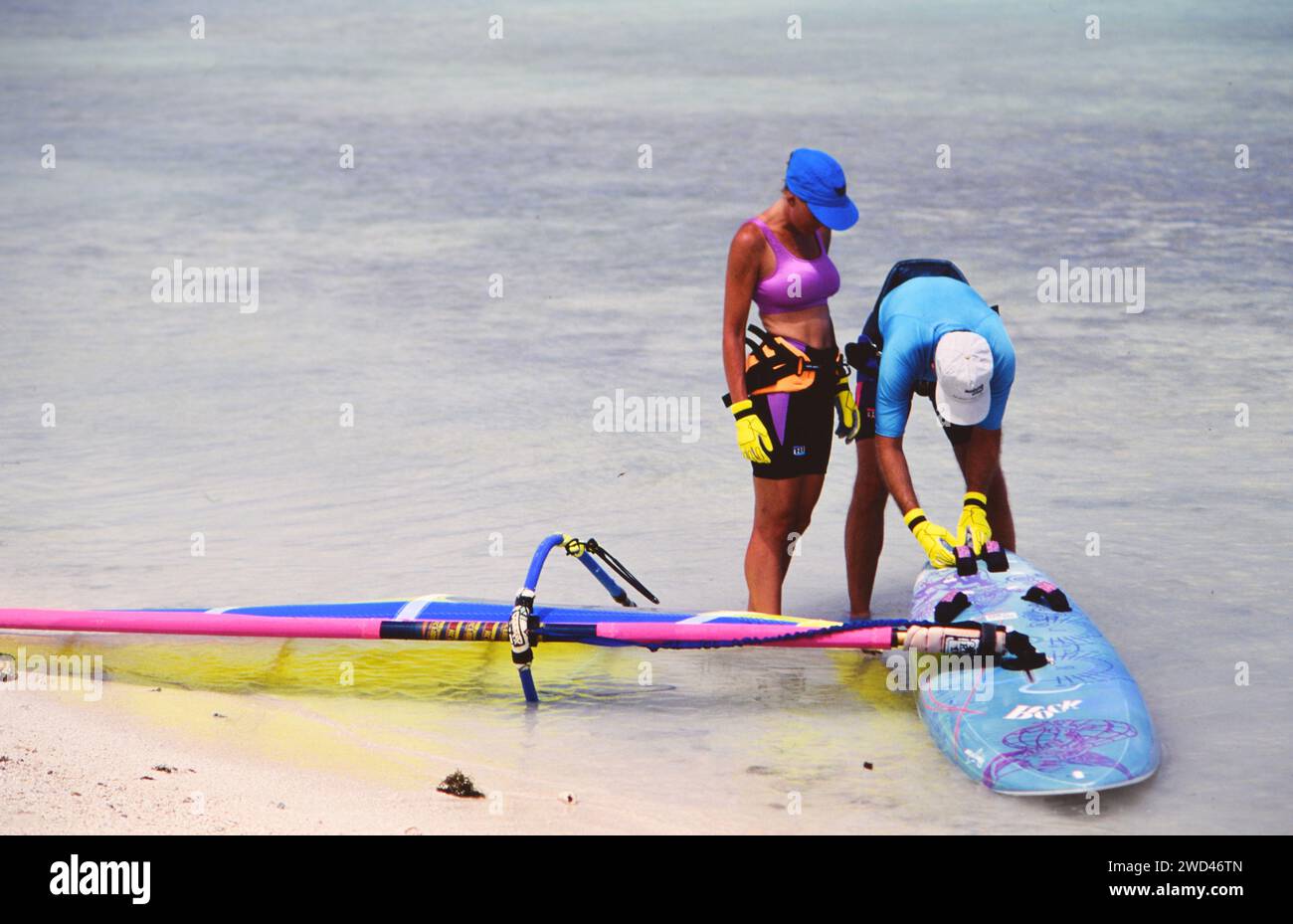 A female windsurfing student learning to rig her board in Aruba ca ...