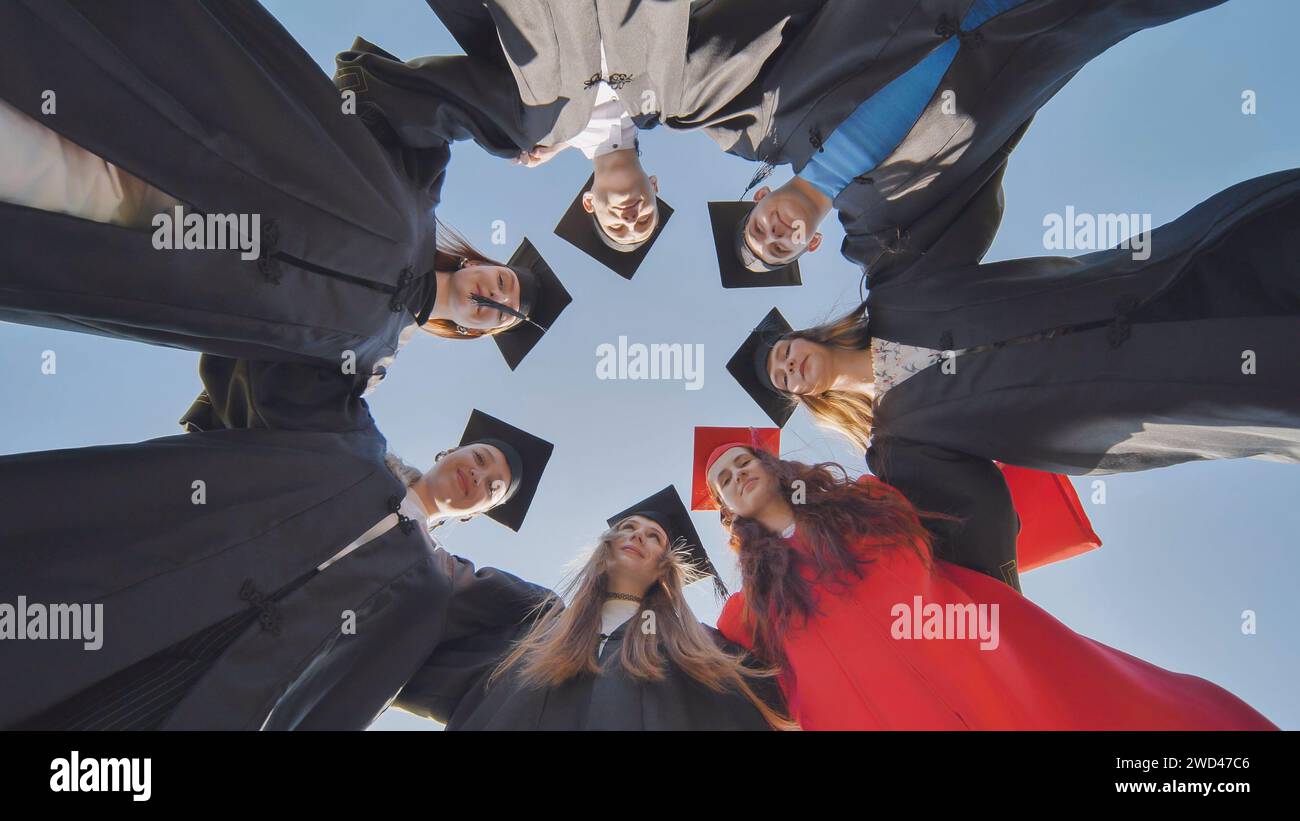 College graduates in a circle stand hugging each other Stock Photo - Alamy