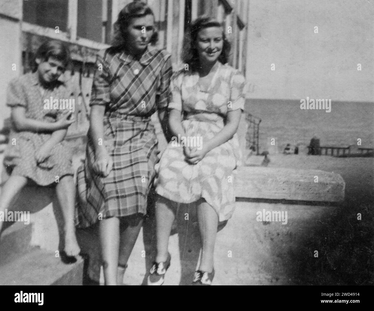 An antique photo shows three girls, pupils of an orphanage, sitting on ...