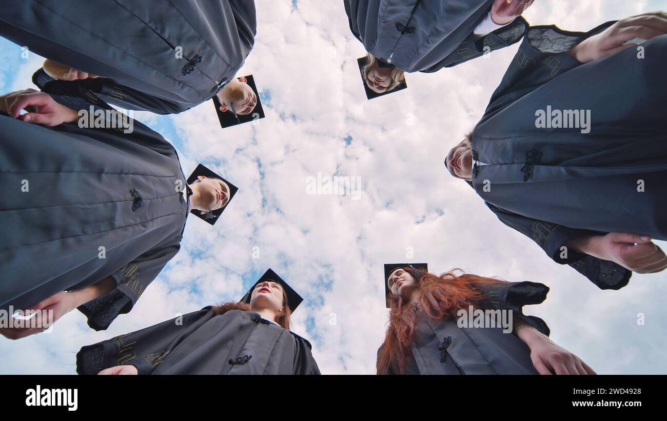 Group of happy successful graduates in academic hats and robes standing ...