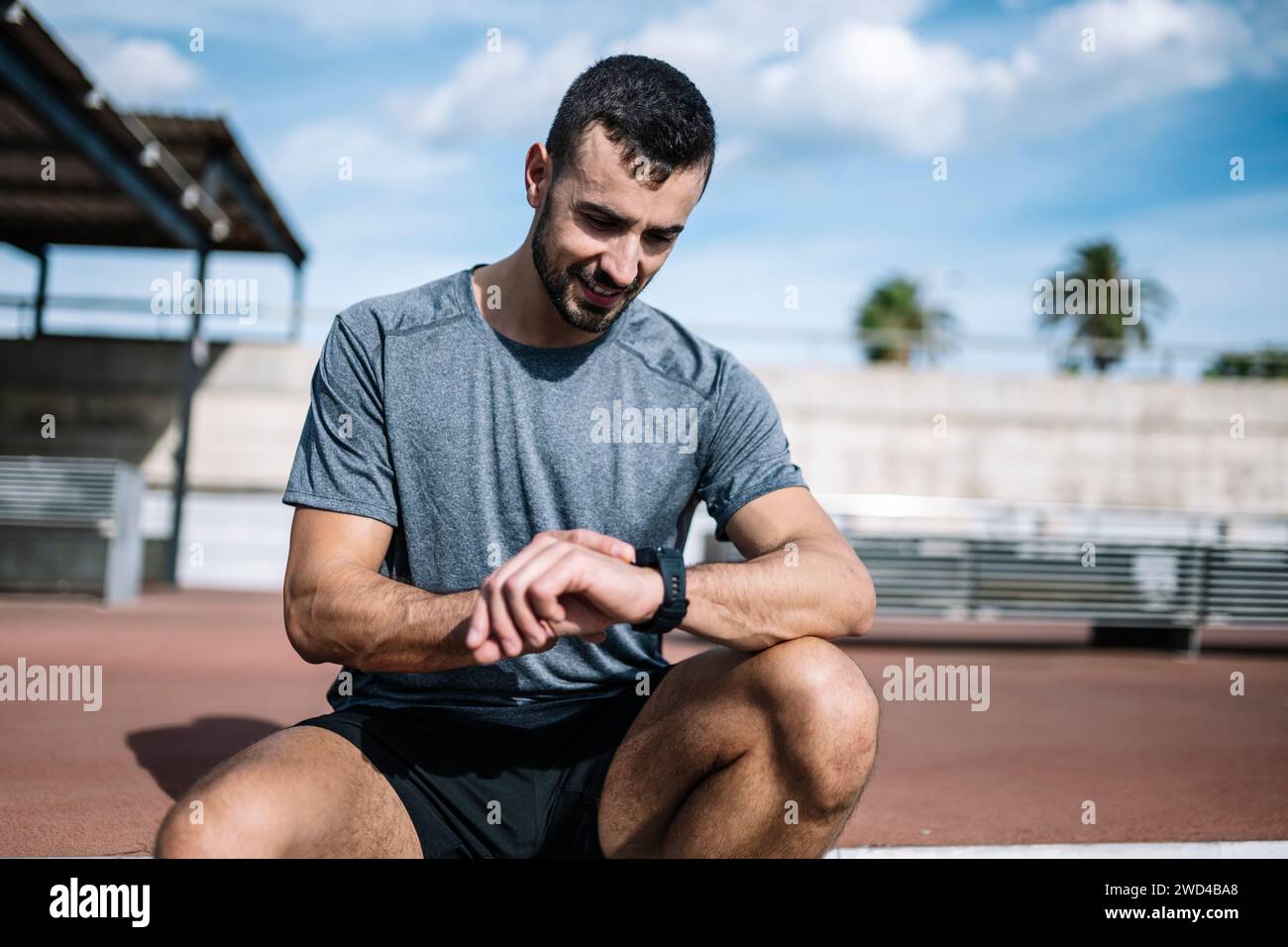 Fitness male looking his watch checking running time after workout ...