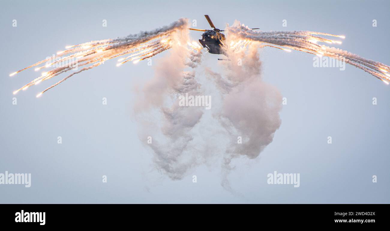 Helicopter deploying flares and chaff- (NH90 military helicopter) a ...