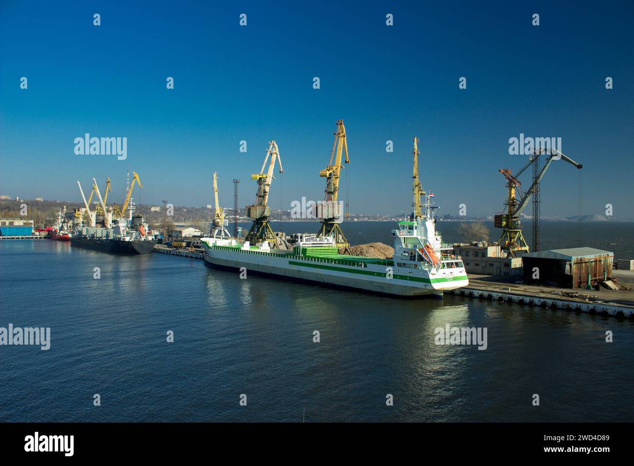 Cargo ship docked at international port, cranes load containers for ...