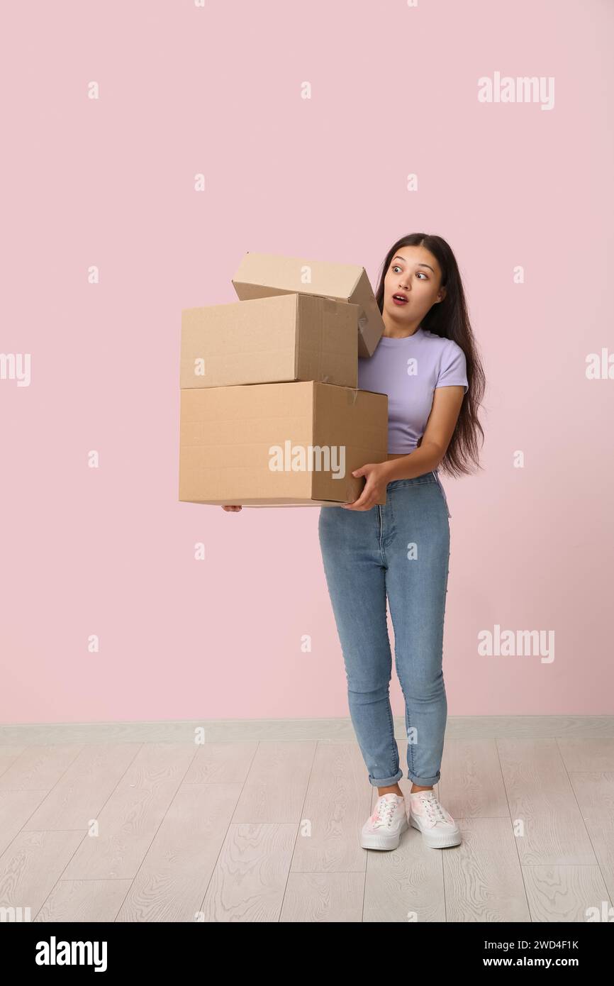 Pretty young woman carrying many parcels near pink wall Stock Photo - Alamy