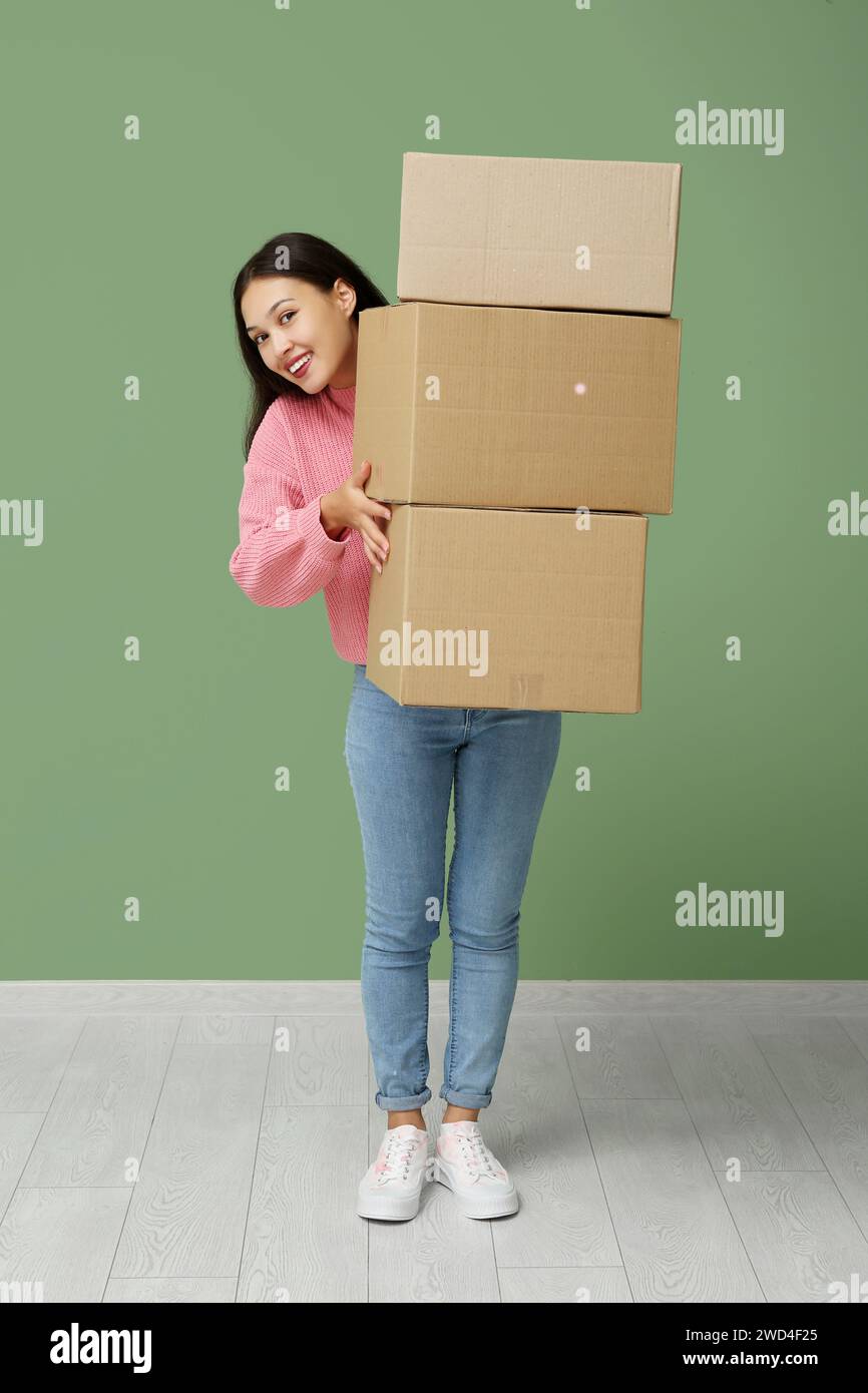 Pretty young woman carrying many parcels near green wall Stock Photo ...