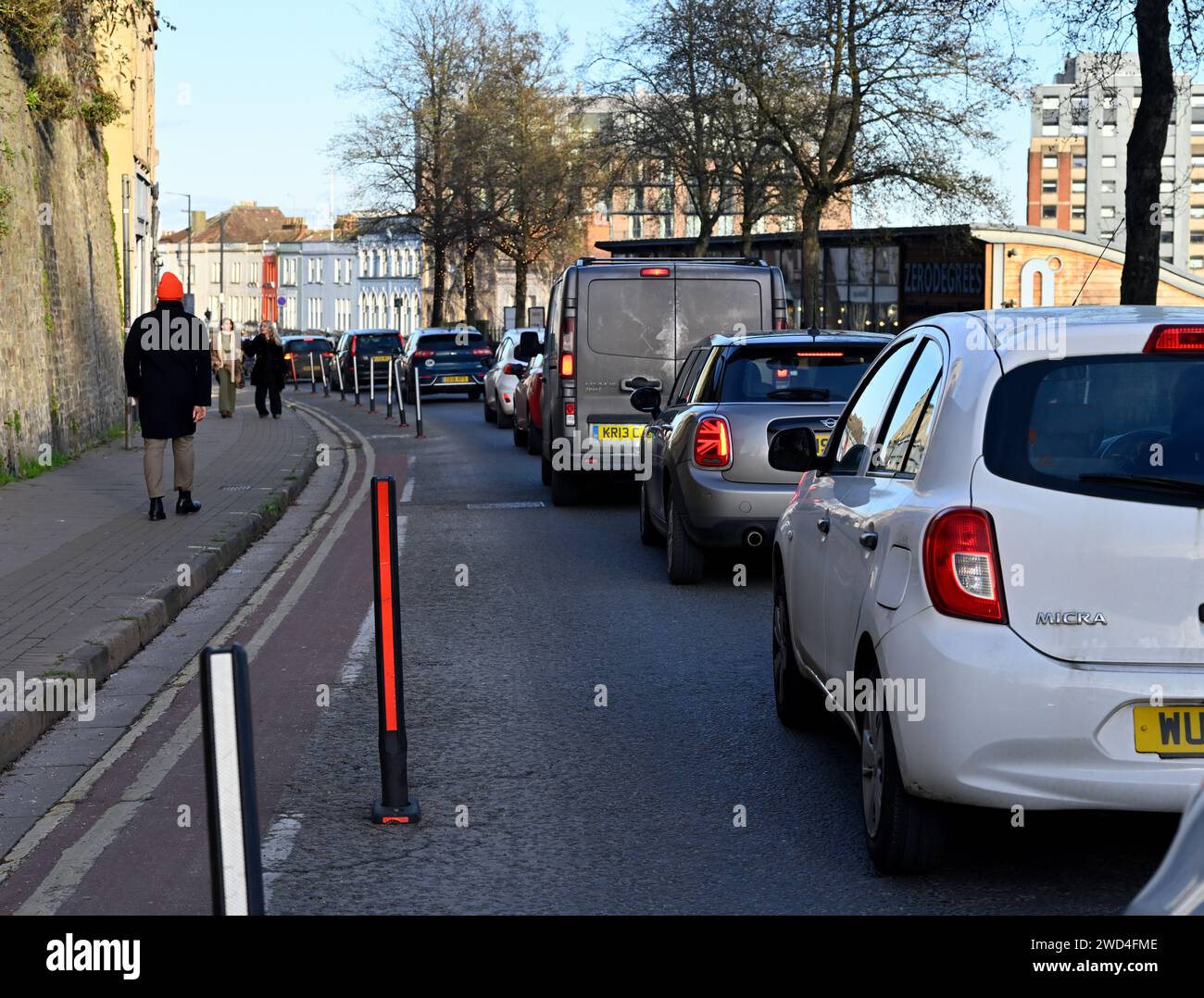 Traffic congestion with long tailback of cars next to empty cycle lane ...