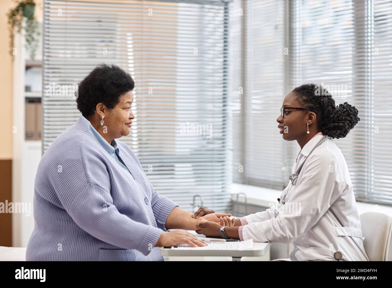 Cheerful Doctor Checking Patients Pulse by Hand Stock Photo - Alamy