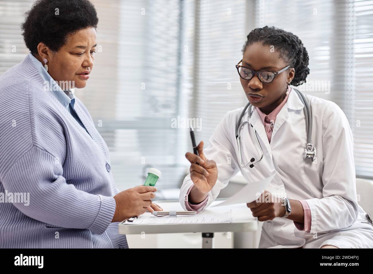 Doctor Showing Prescription to Female Patient Stock Photo - Alamy