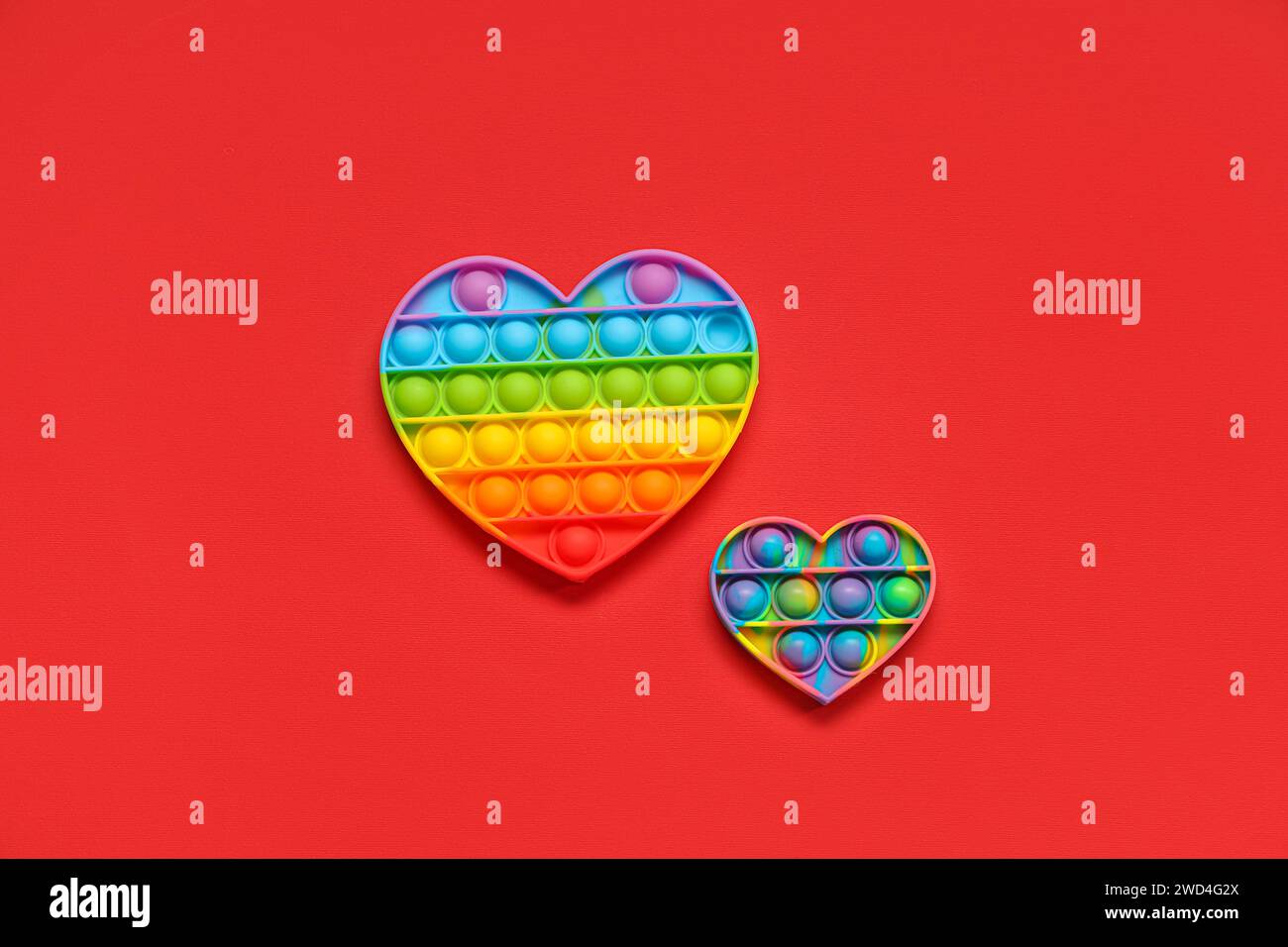 Heart-shaped pop it fidget toys on red background. Valentine's day ...