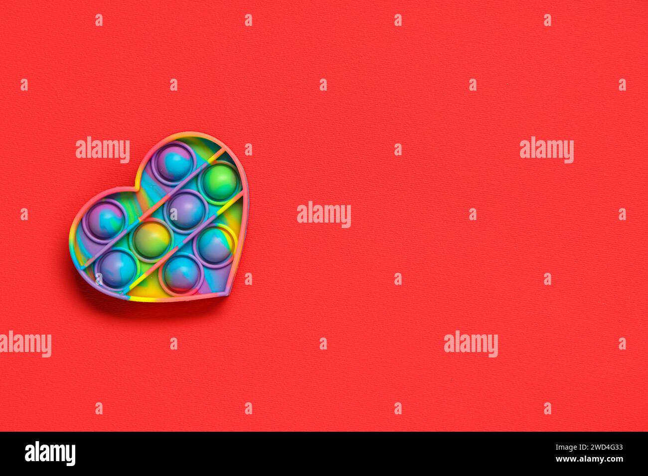 Heart-shaped pop it fidget toy on red background. Valentine's day ...