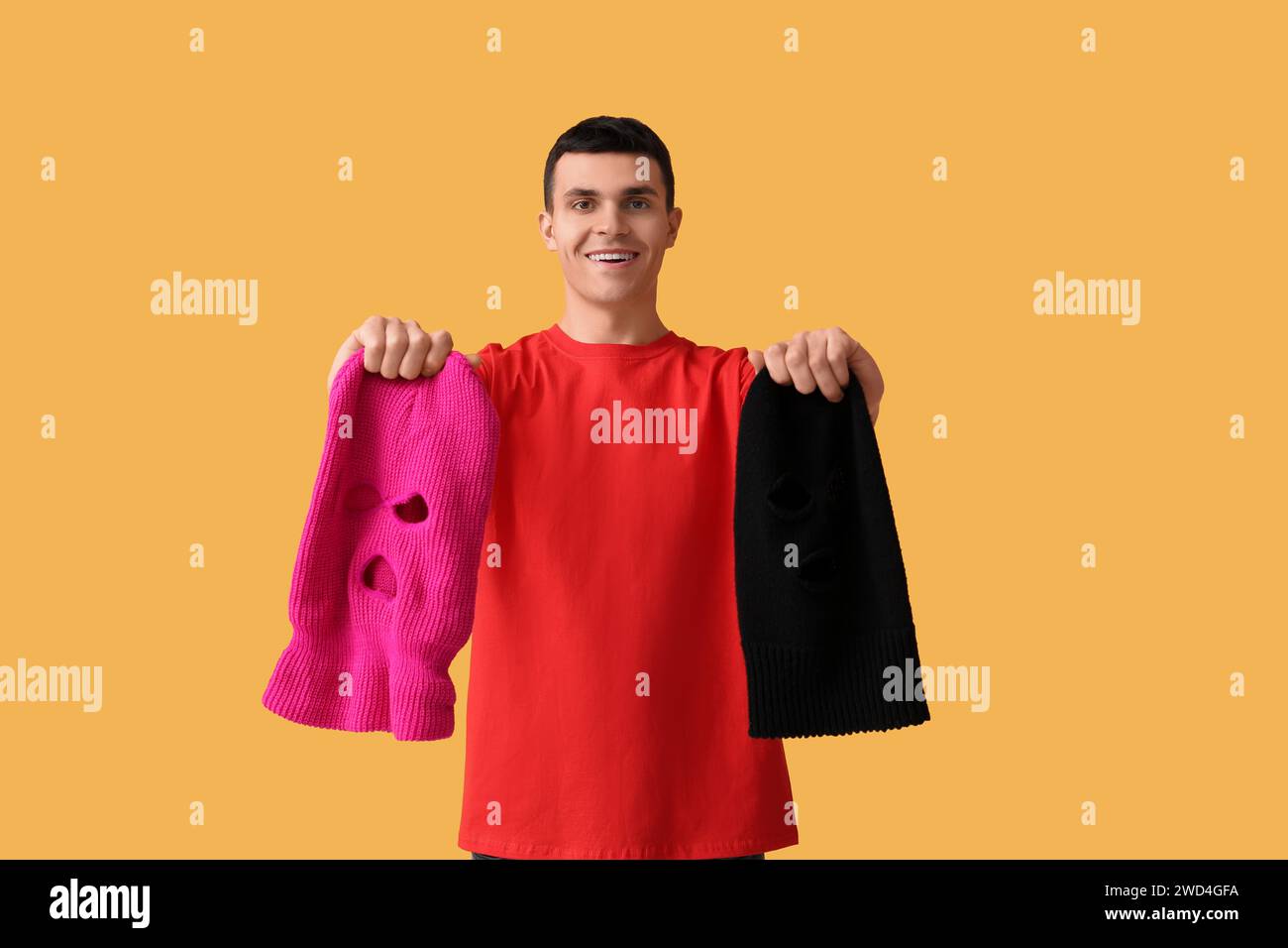 Handsome young happy man with balaclavas on yellow background Stock ...