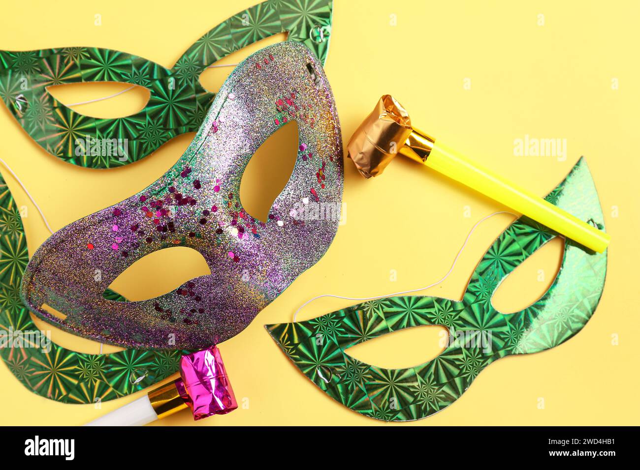 Carnival masks with party horns for Mardi Gras celebration on yellow ...