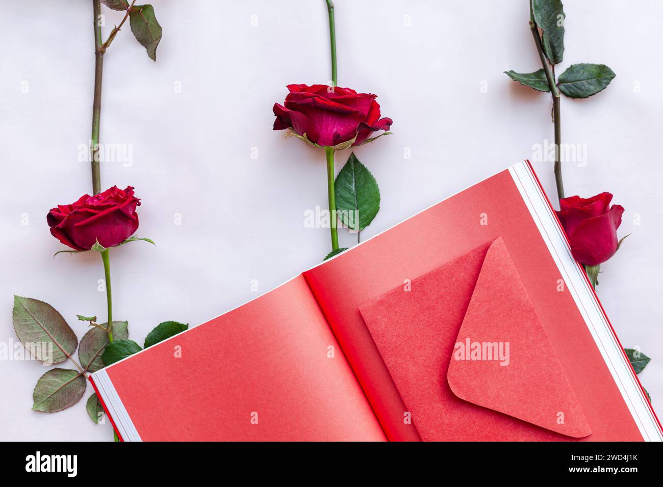 An open book adorned with vibrant red roses and lush leaves Stock Photo ...