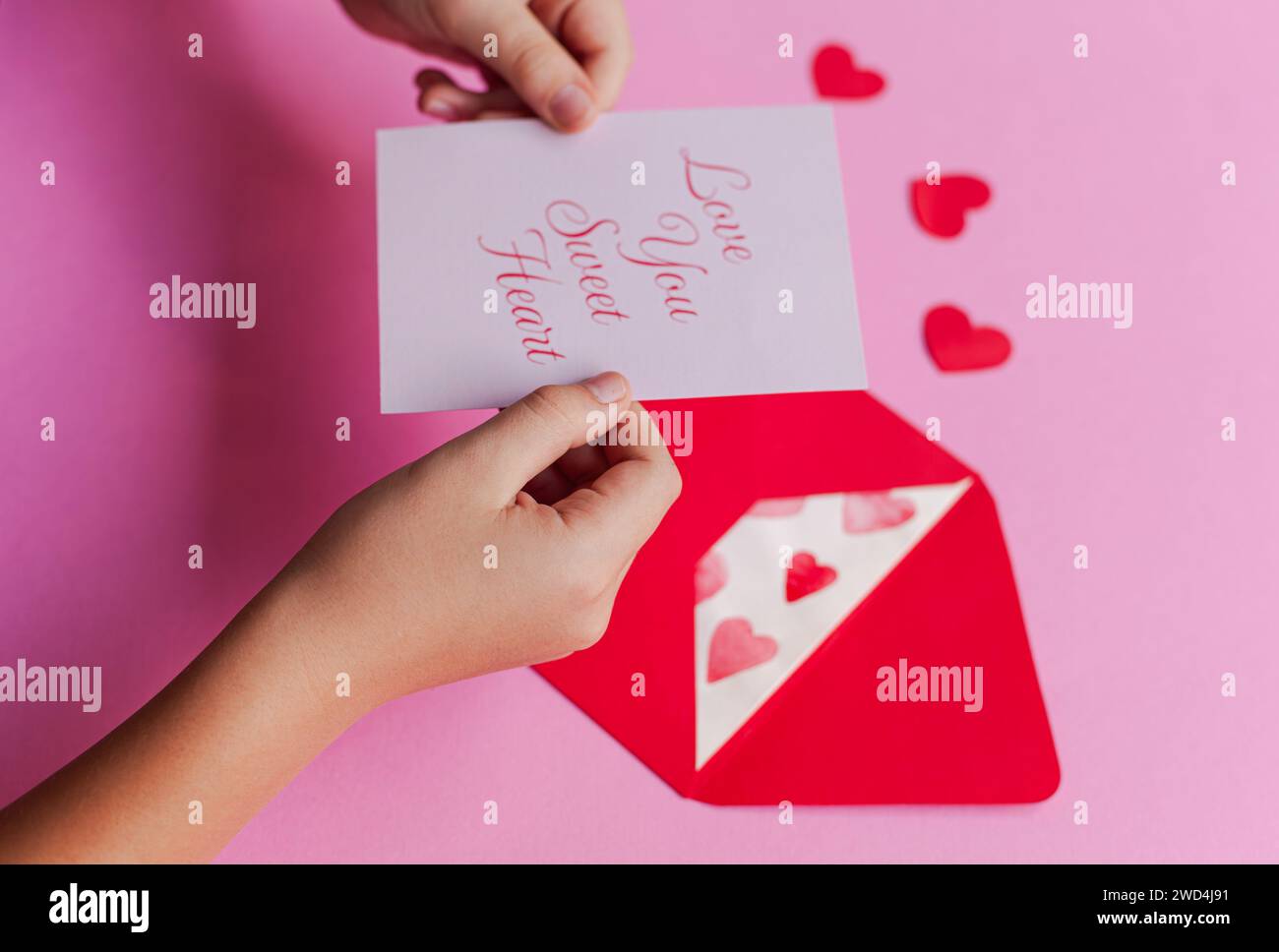 Woman showcasing a white card within a vibrant red envelope ...
