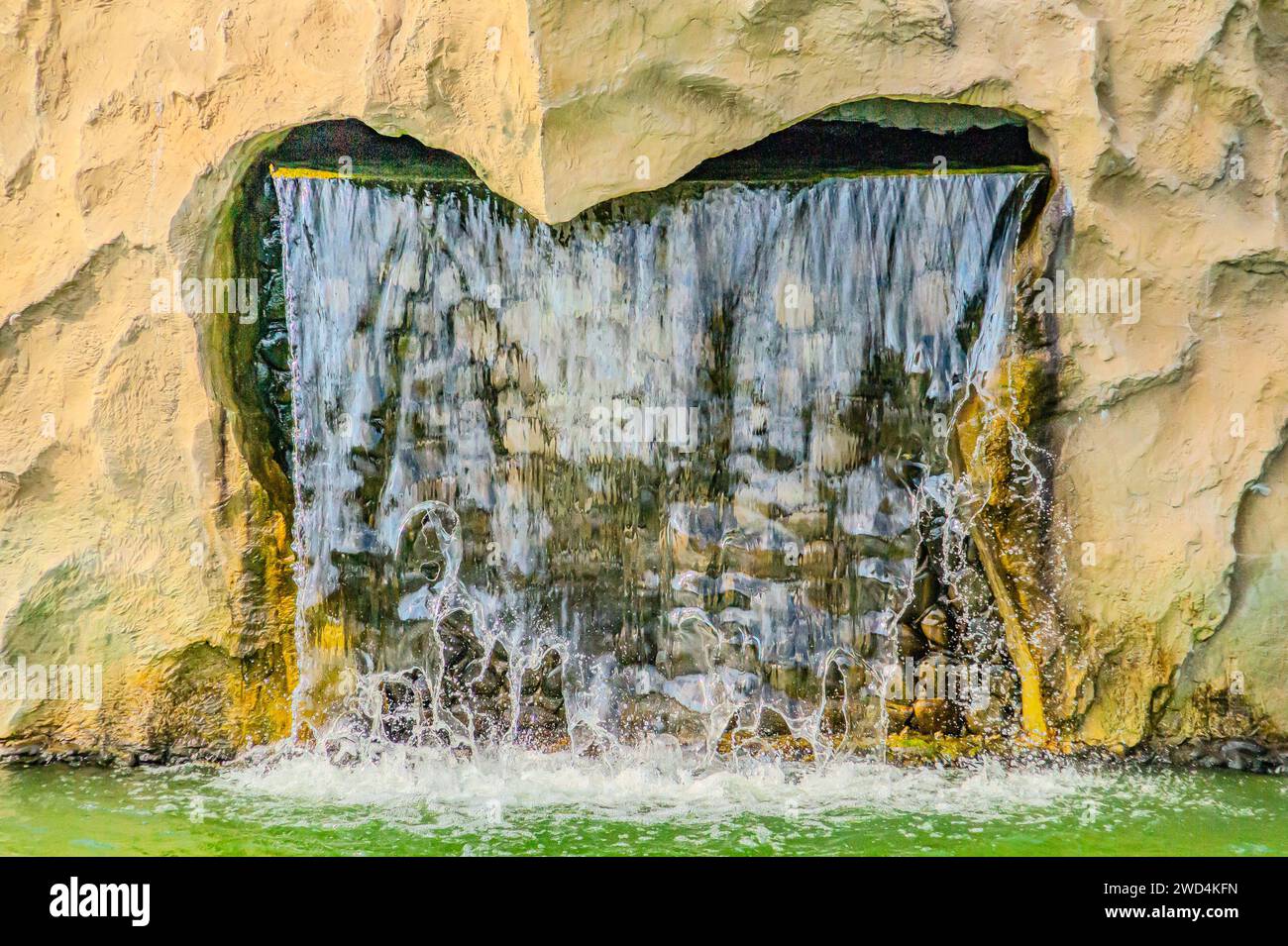 A small decorative waterfall in the garden. Landscape design. Small ...