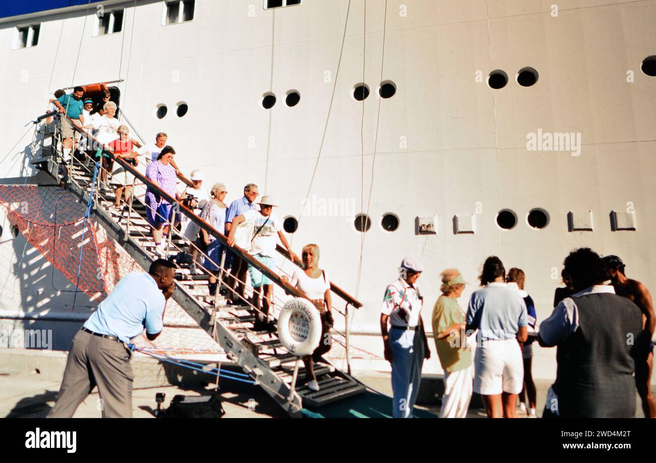 Cruise ship passengers file down a stairway on a dock in Nassau ca ...