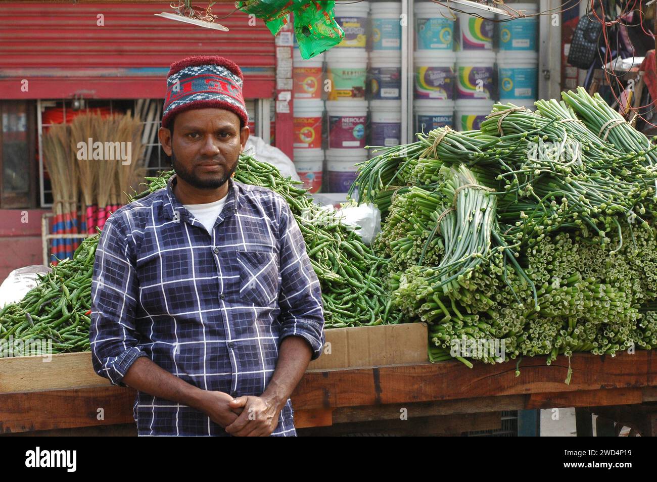 Dhaka, Bangladesh. 19th Jan, 2024. A green chilies vendor waits for ...