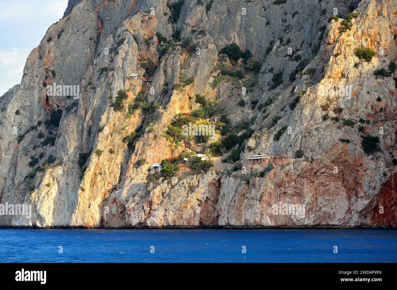 Cliff rising from blue ocean with train on top Stock Photo - Alamy